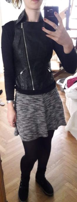 Kožni prsluk, siva suknja, crni pulover bez rukava i crne čizmice