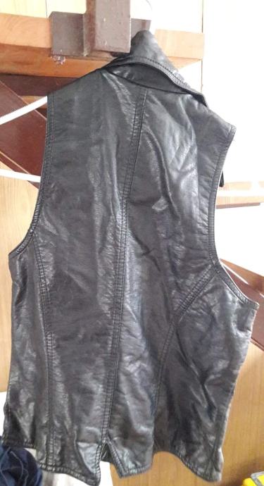 Kožni prsluk, siva suknja, crni pulover bez rukava i crne čizmice