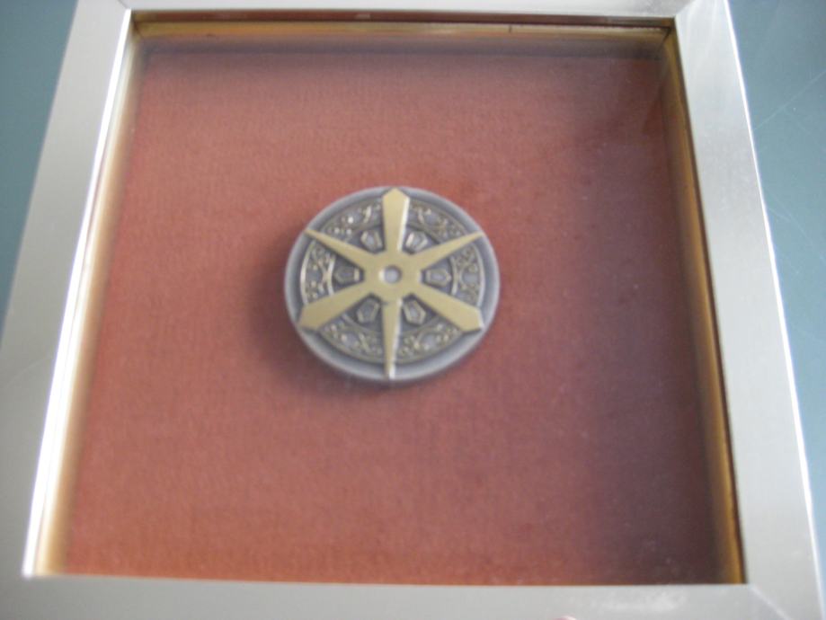 Medalja promjer 5 cm na crvenom samtu u okviru boje mesinga 18x18 cm,