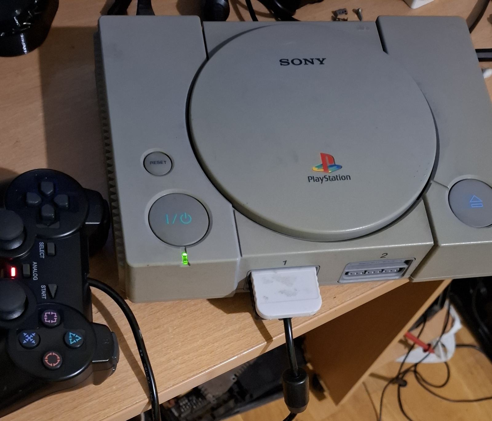 Ps1 s joystickom, igrama, kablovima i memorijskom